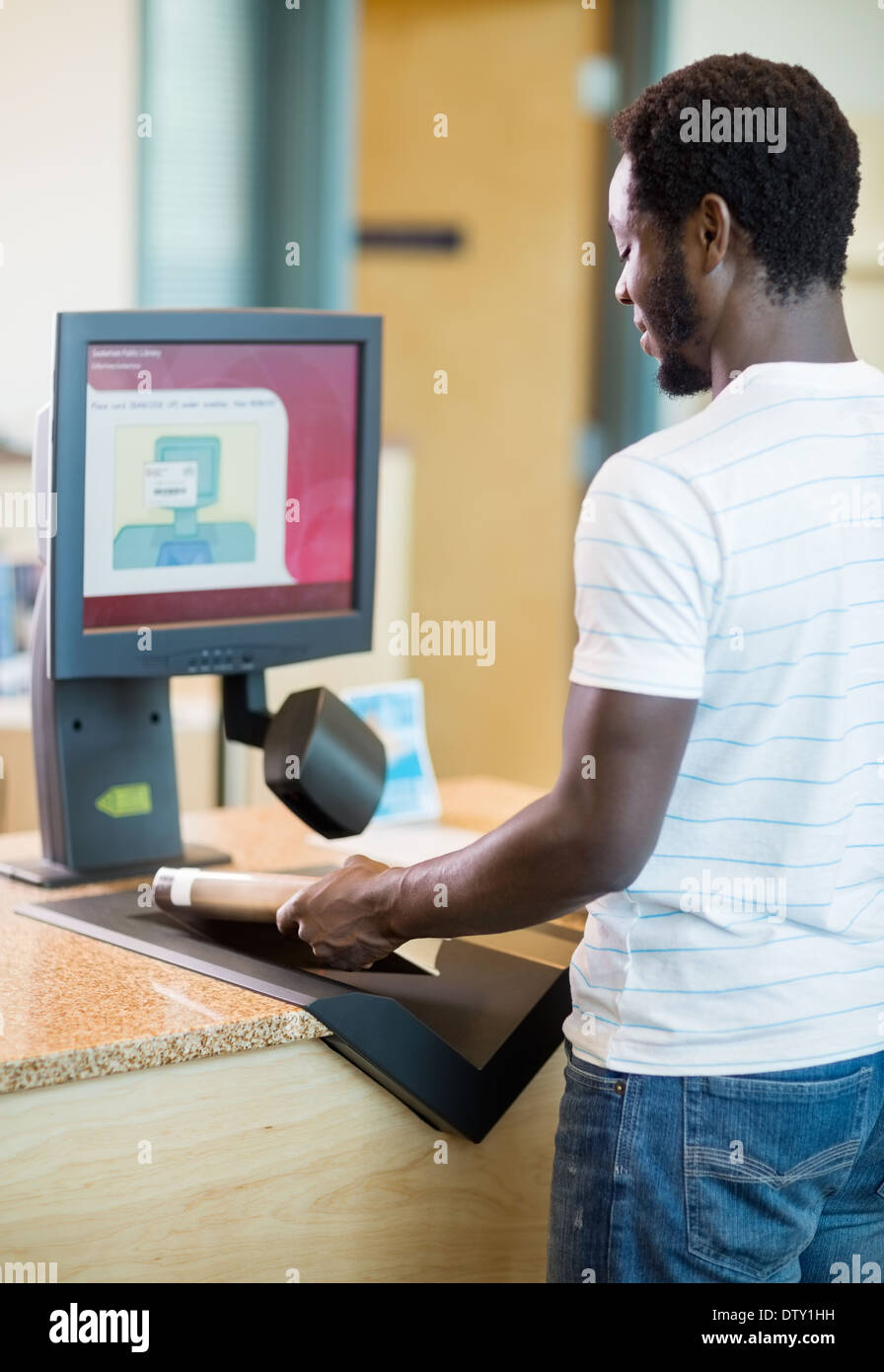 Librarian Scanning Books At Bookstore Counter Stock Photo - Alamy