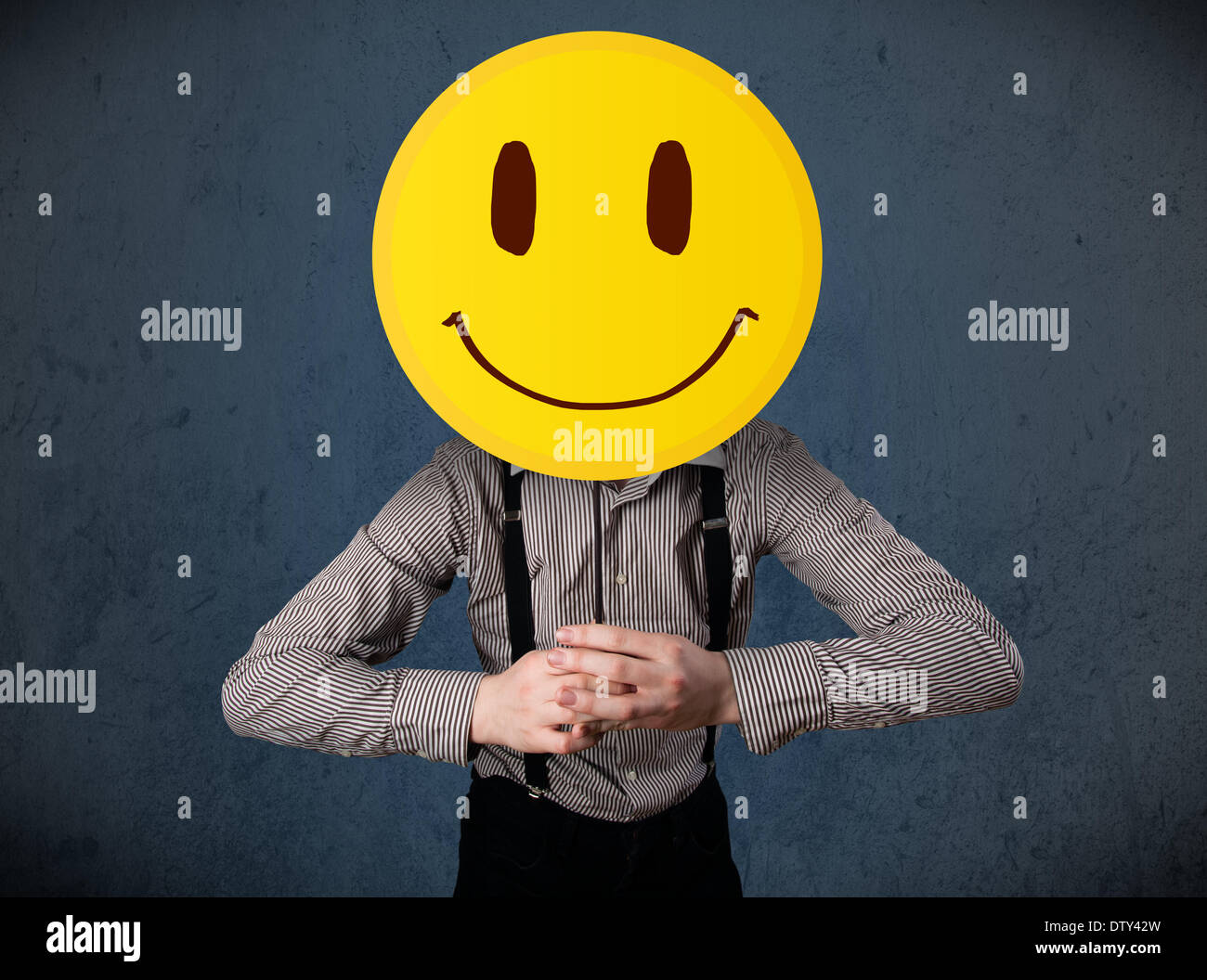 Businessman holding a smiley face emoticon Stock Photo - Alamy