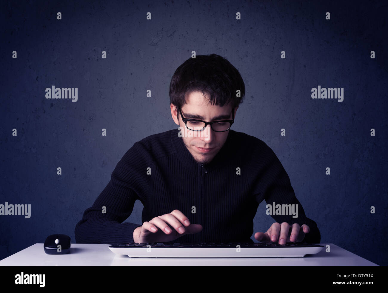Hacker working with keyboard on blue background Stock Photo - Alamy