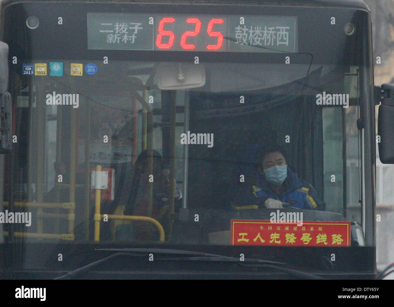 Beijing, China. 24th Feb, 2014. A bus driver wears a mask during work ...