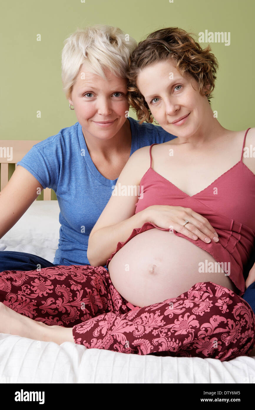 Caucasian pregnant lesbian couple relaxing on bed Stock Photo - Alamy