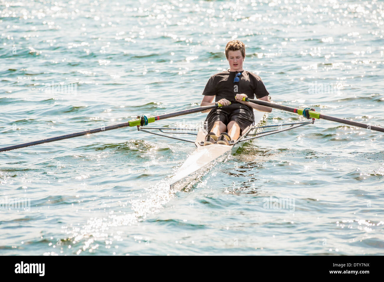 Mixed race teenage boy rowing on lake Stock Photo - Alamy