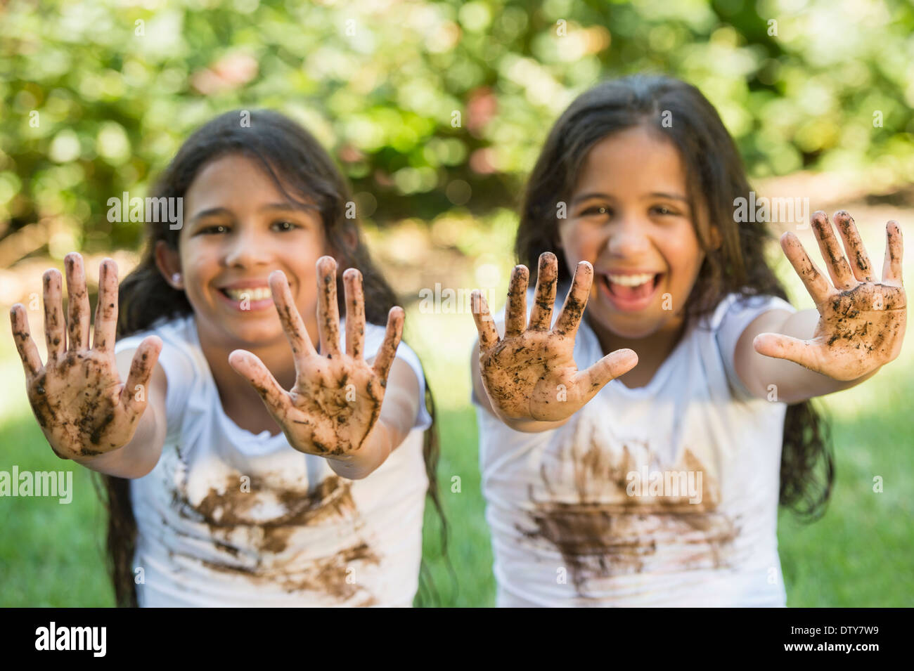 Mixed race girls covered in mud outdoors Stock Photo - Alamy