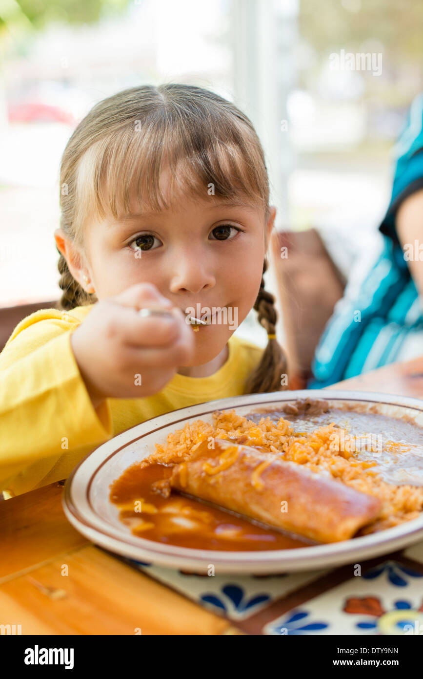 Hispanic girl eating dinner at table Stock Photo - Alamy