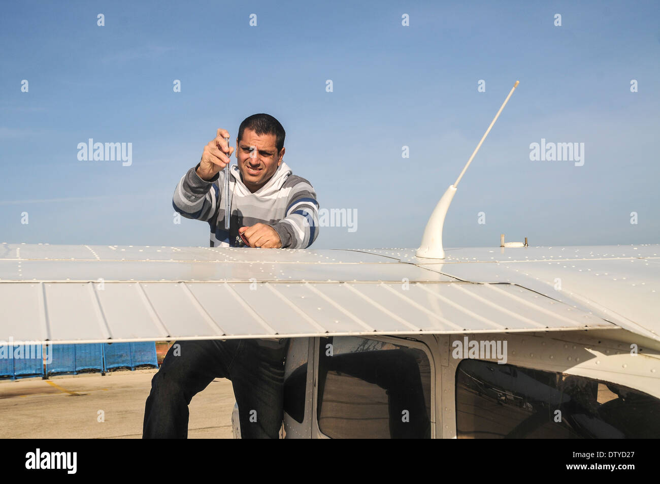Pilot perform a preflight check and checks the petrol quality on a ...