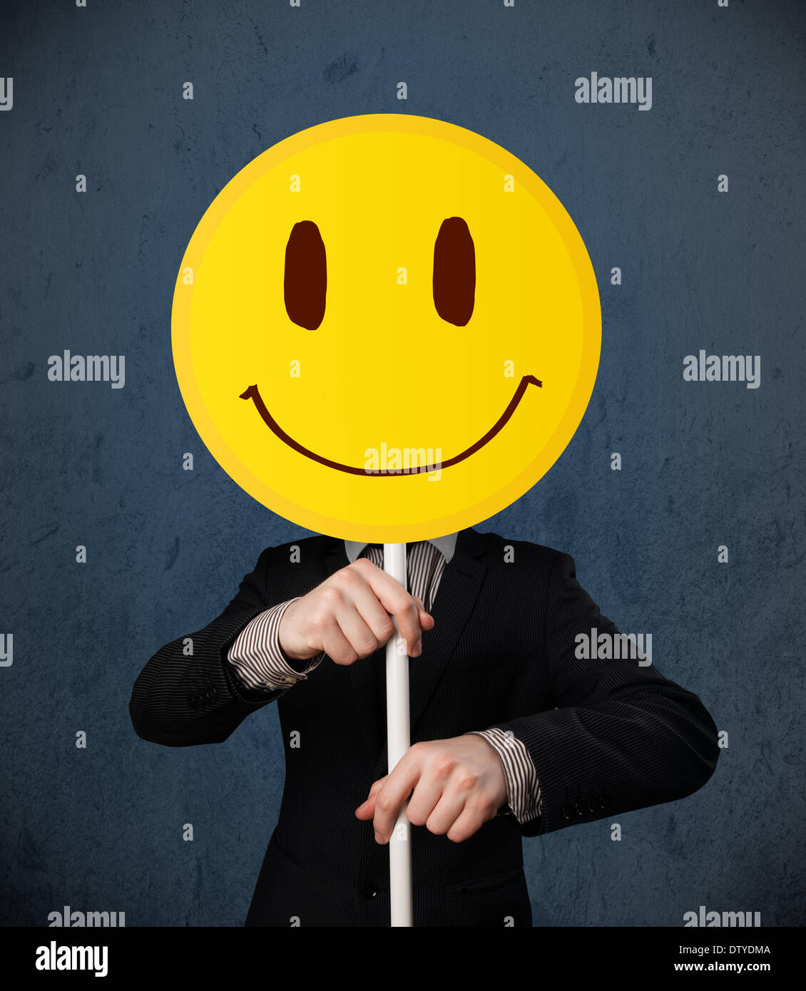 Businessman holding a smiley face emoticon Stock Photo - Alamy