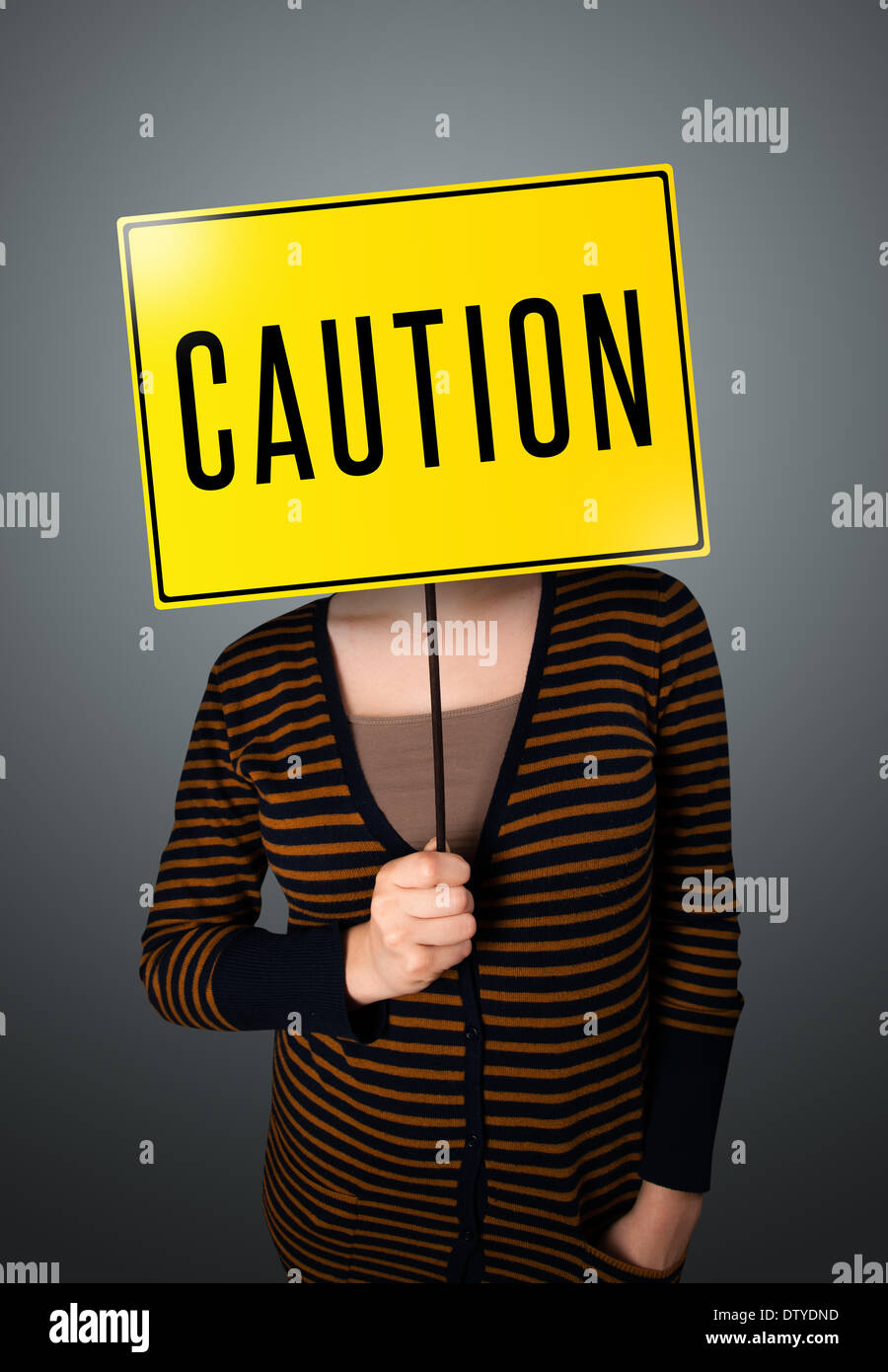 Young woman holding a caution sign Stock Photo - Alamy