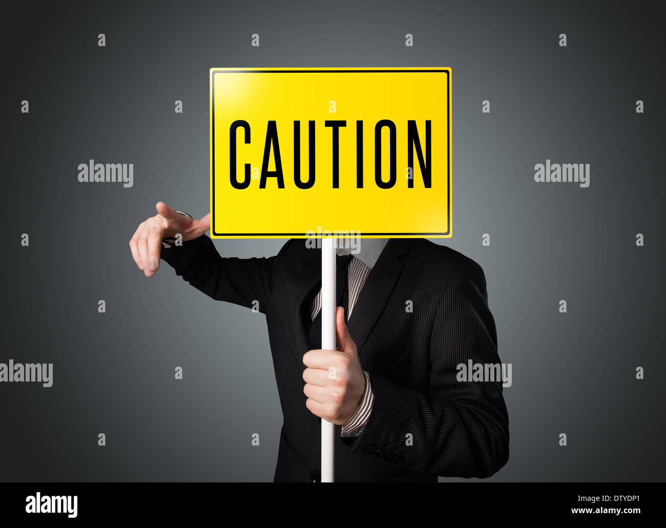 Businessman holding a caution sign Stock Photo - Alamy