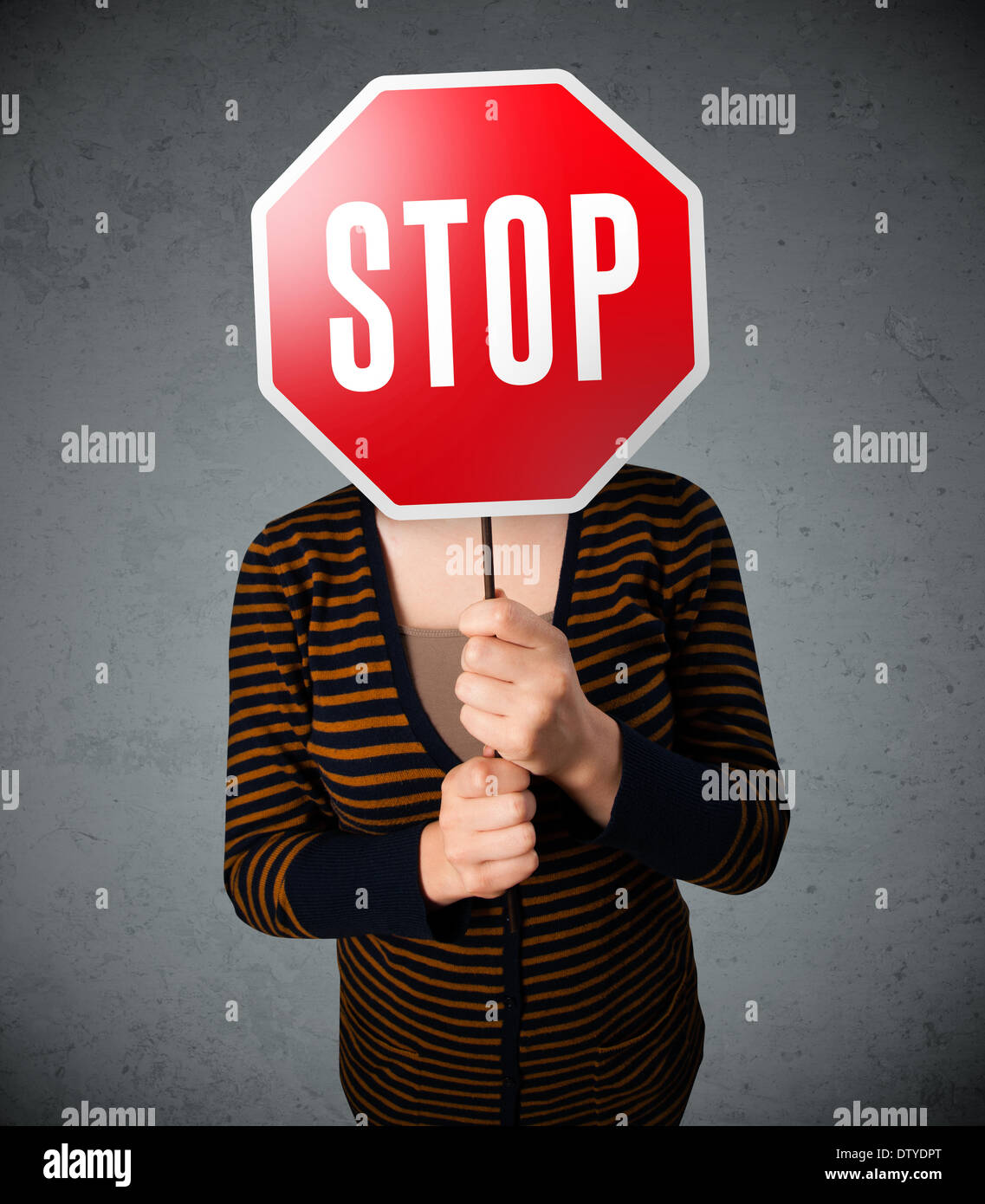 Young woman holding a stop sign Stock Photo - Alamy