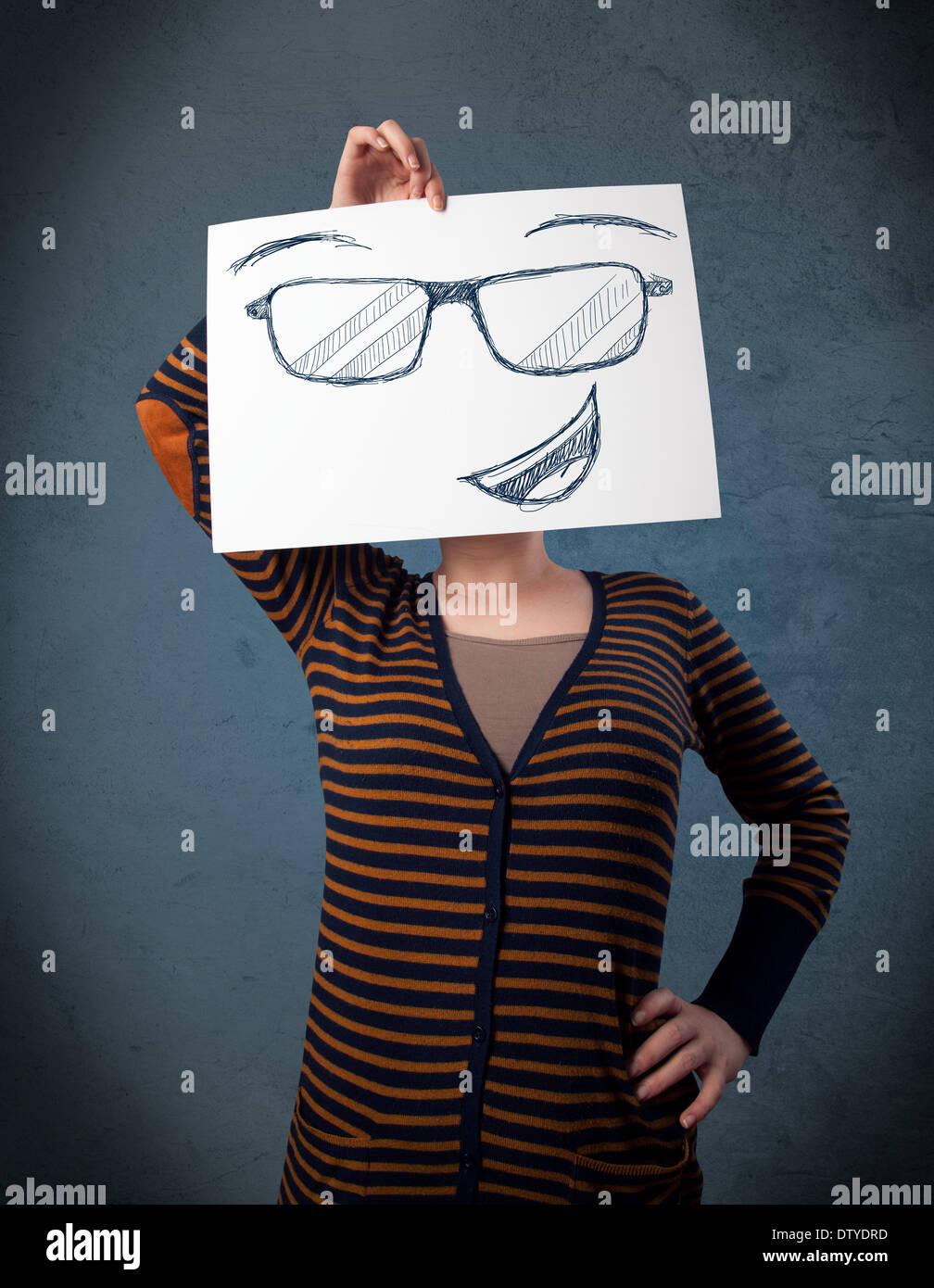 Woman holding a paper with smiley face in front of her head Stock Photo ...