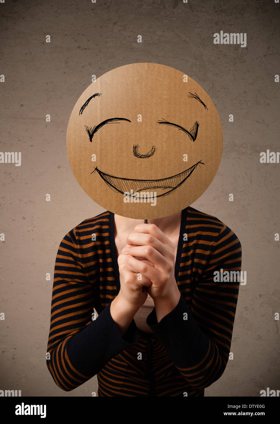 Young woman holding a smiley face board Stock Photo - Alamy