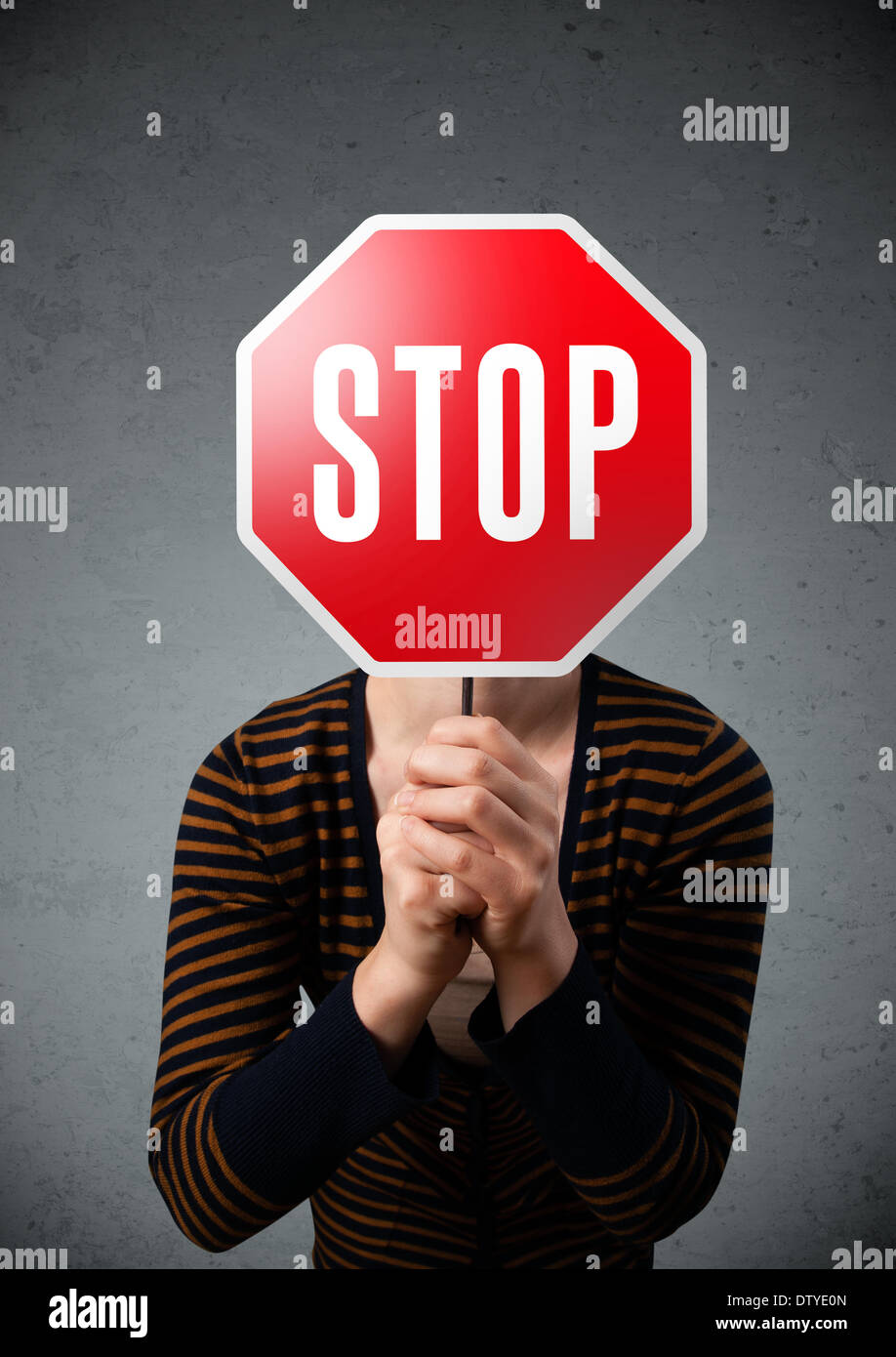 Young woman holding a stop sign Stock Photo - Alamy