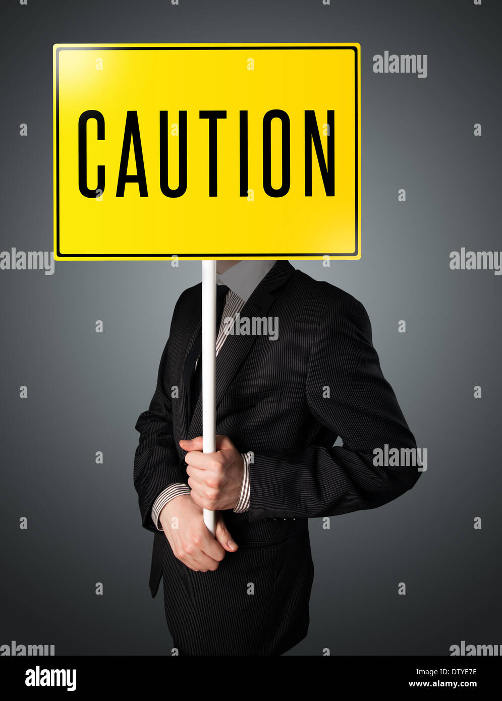 Businessman holding a caution sign Stock Photo - Alamy
