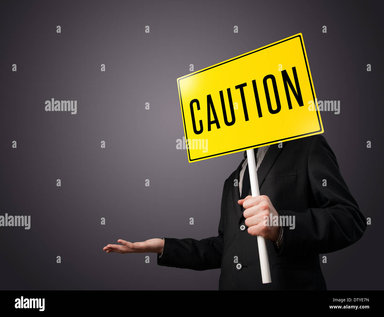 Businessman holding a caution sign Stock Photo - Alamy