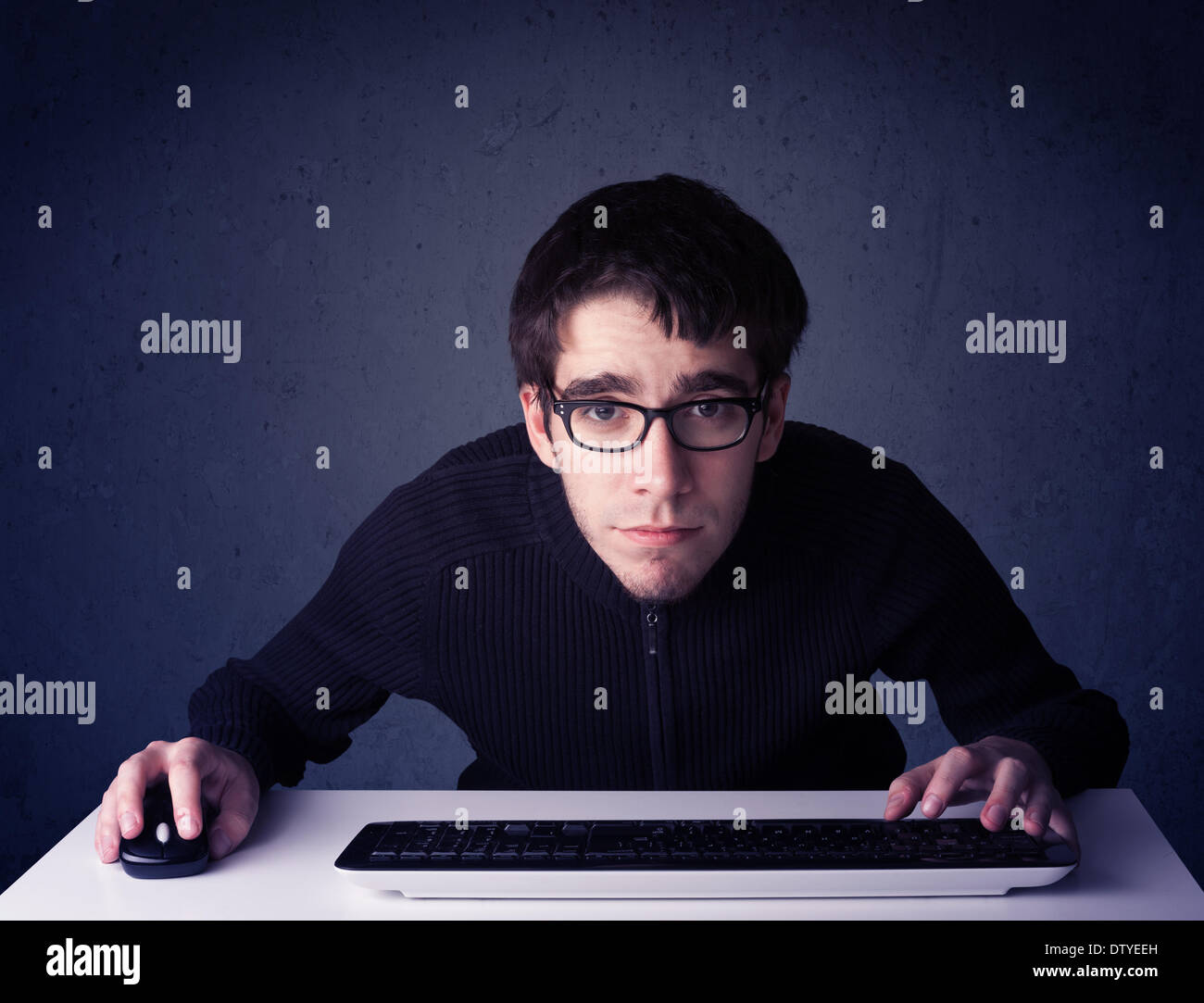 Hacker working with keyboard on blue background Stock Photo - Alamy