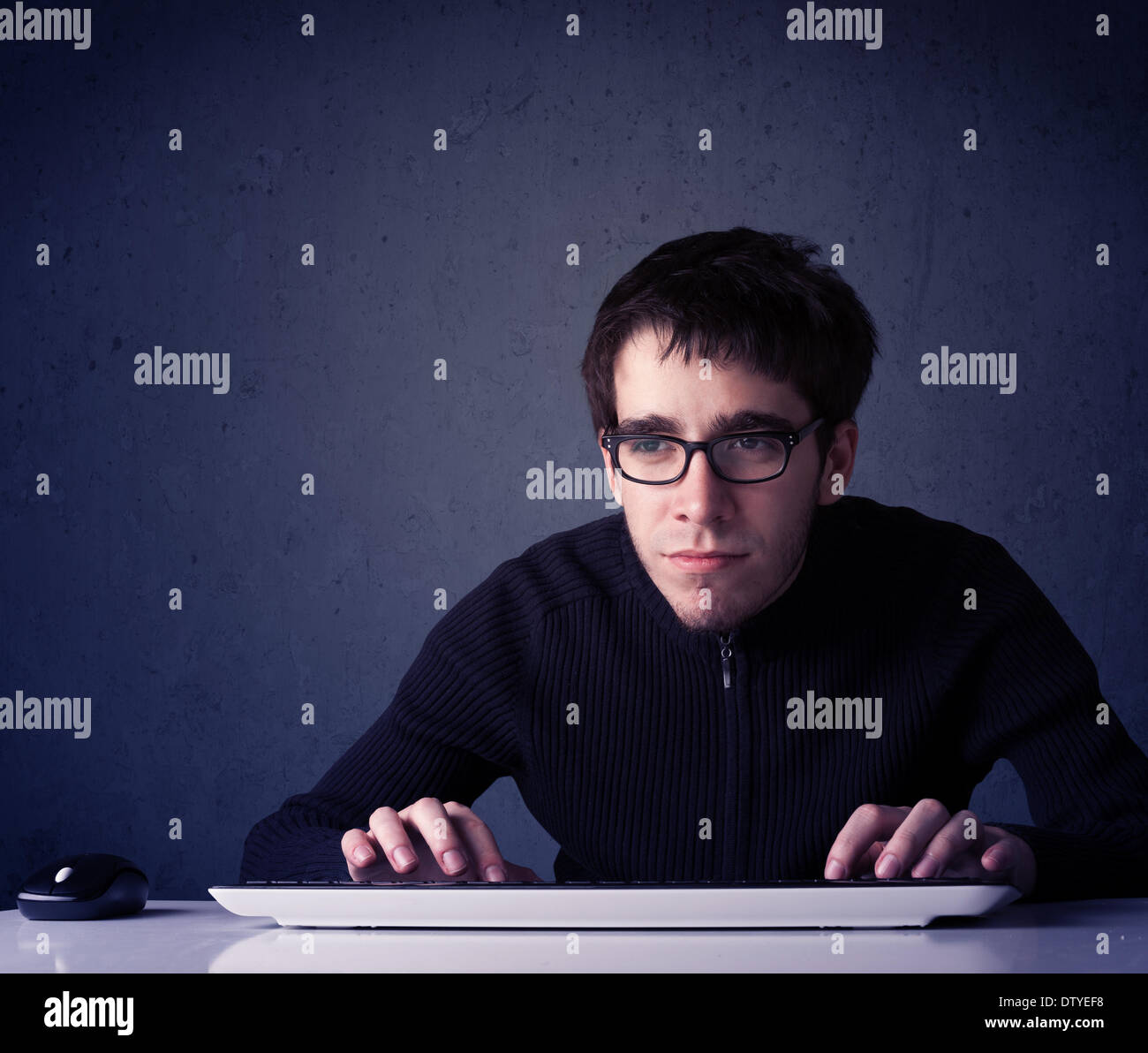 Hacker working with keyboard on blue background Stock Photo - Alamy