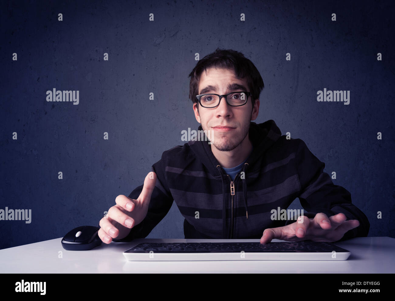 Hacker working with keyboard on blue background Stock Photo - Alamy