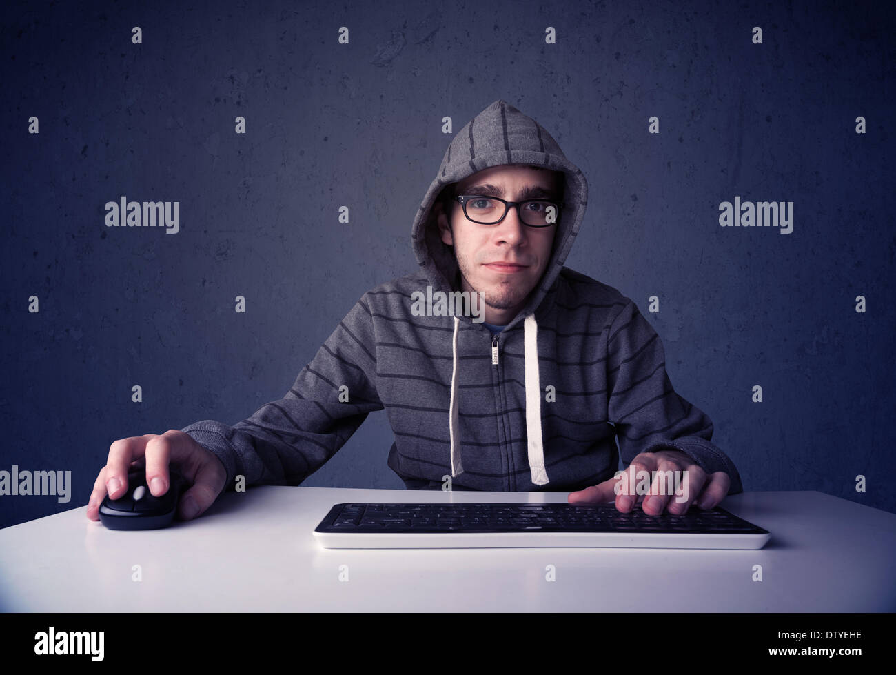 Hacker working with keyboard on blue background Stock Photo - Alamy