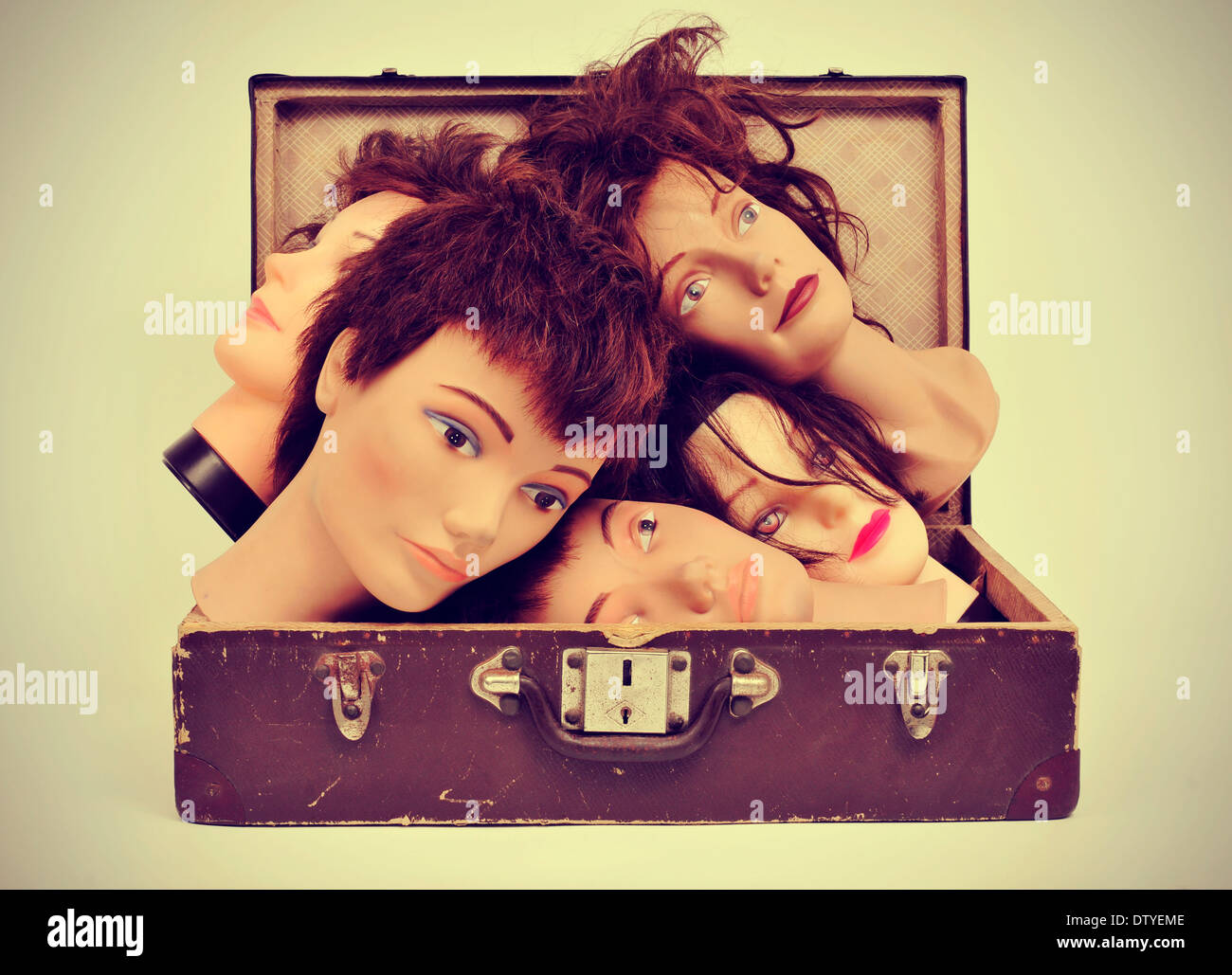 a pile of mannequin heads in an old suitcase with a retro effect Stock ...