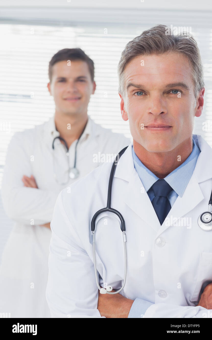 Serious doctor with arms crossed standing Stock Photo - Alamy