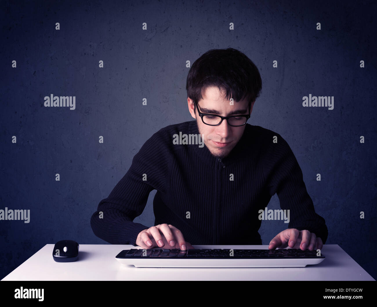 Hacker working with keyboard on blue background Stock Photo - Alamy
