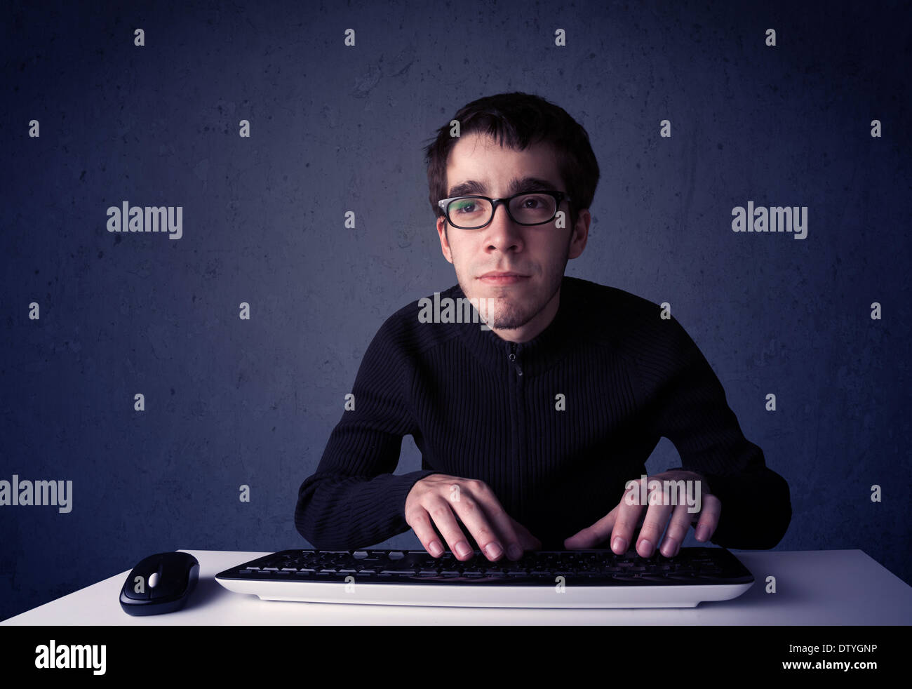 Hacker working with keyboard on blue background Stock Photo - Alamy