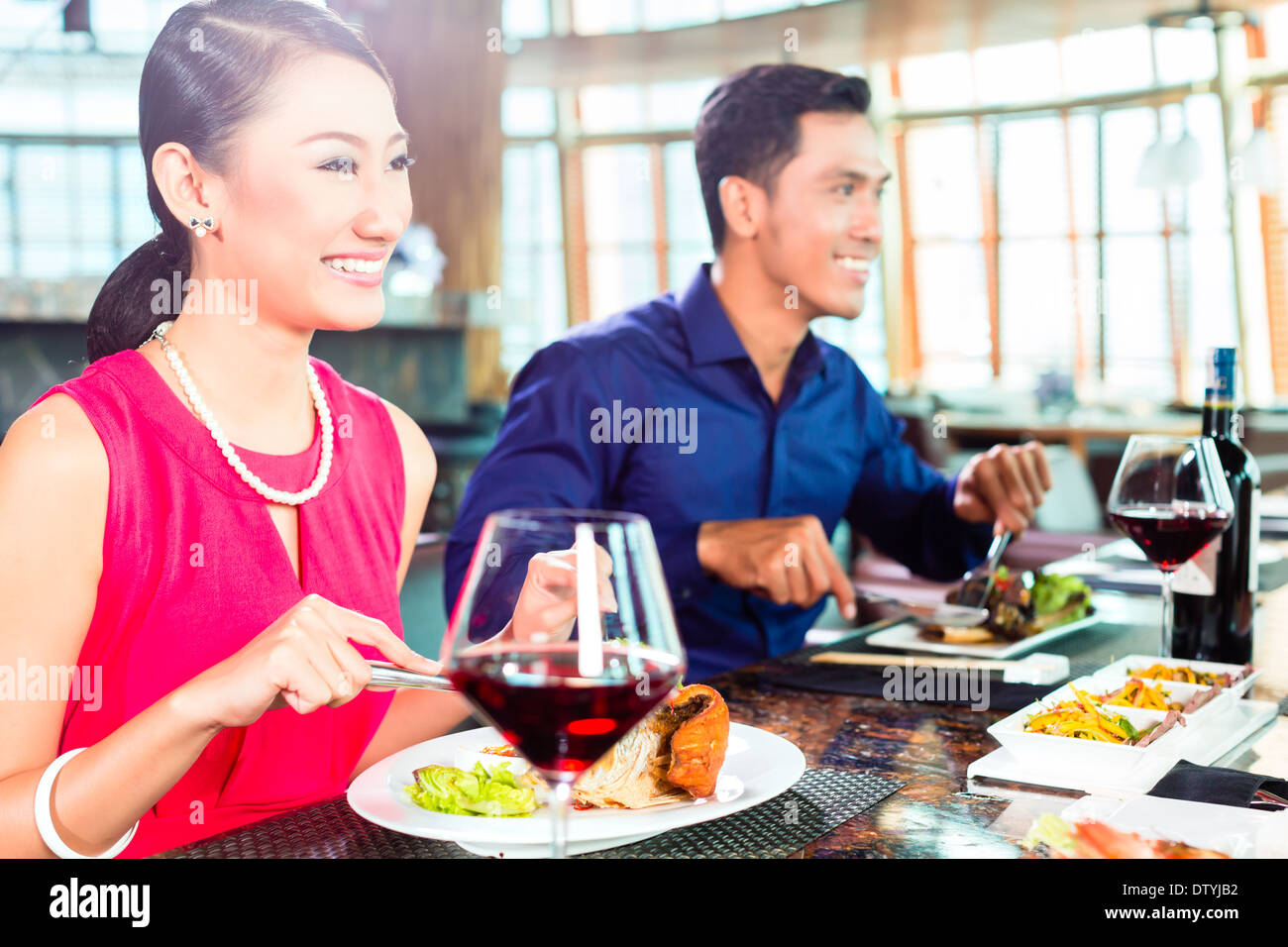 Asian people having dinner and drinking red wine in very fancy ...