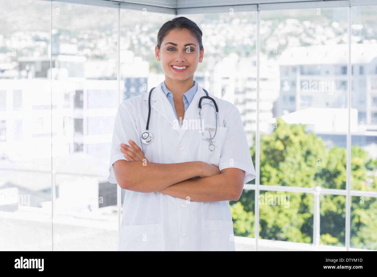 Pretty doctor with arms crossed Stock Photo - Alamy