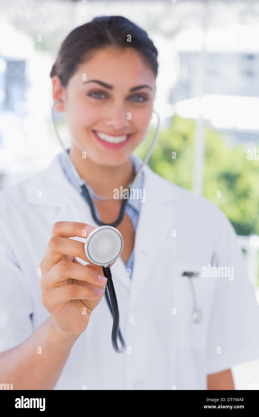 Happy young doctor holding up stethoscope Stock Photo - Alamy