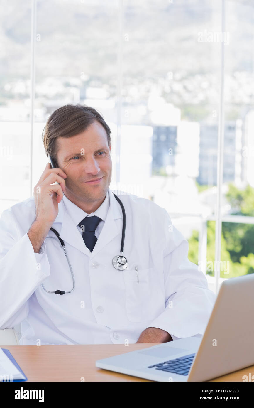 Cheerful doctor phoning in his office Stock Photo - Alamy