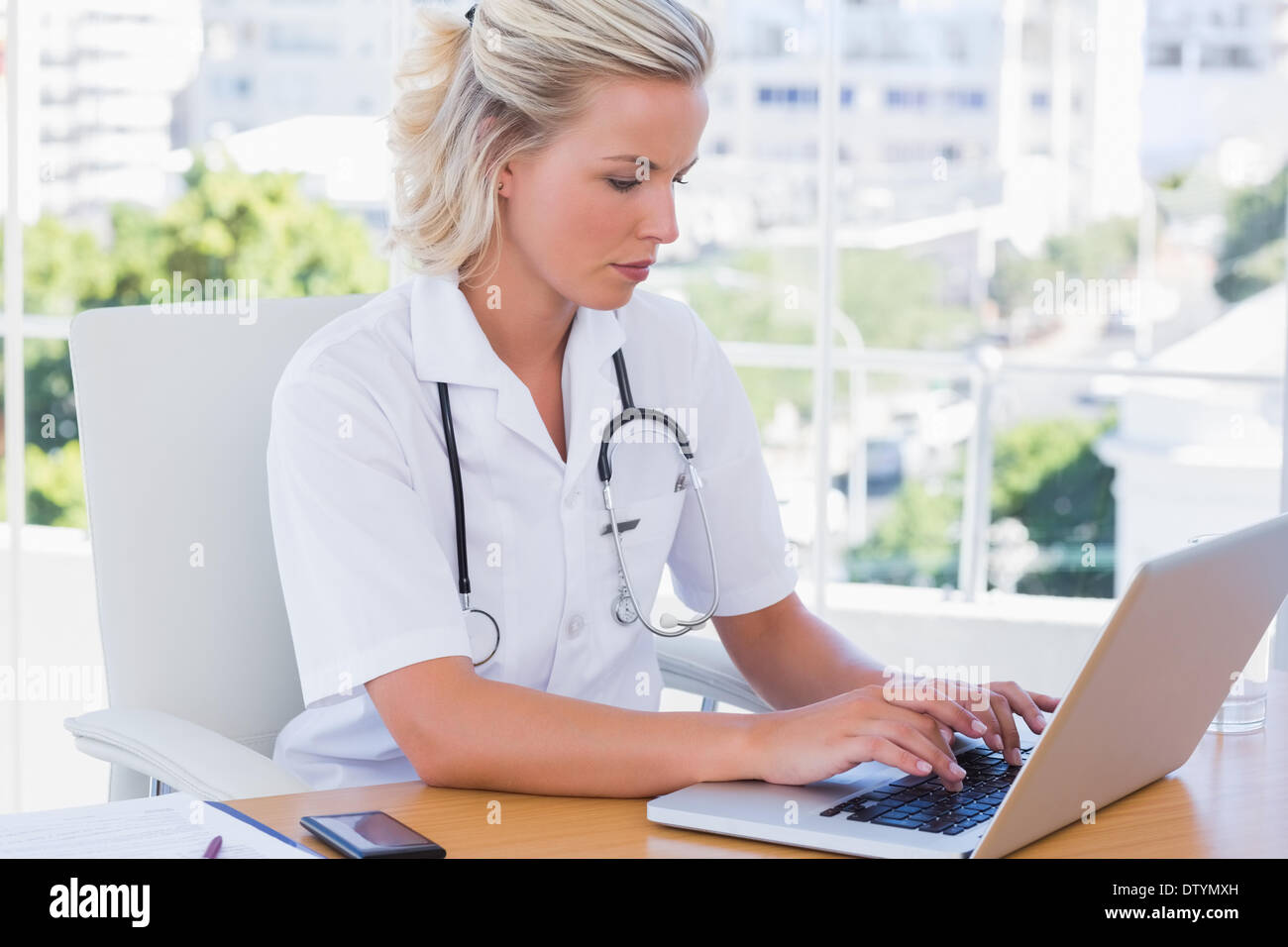 Focused blonde working laptop sitting hi-res stock photography and ...
