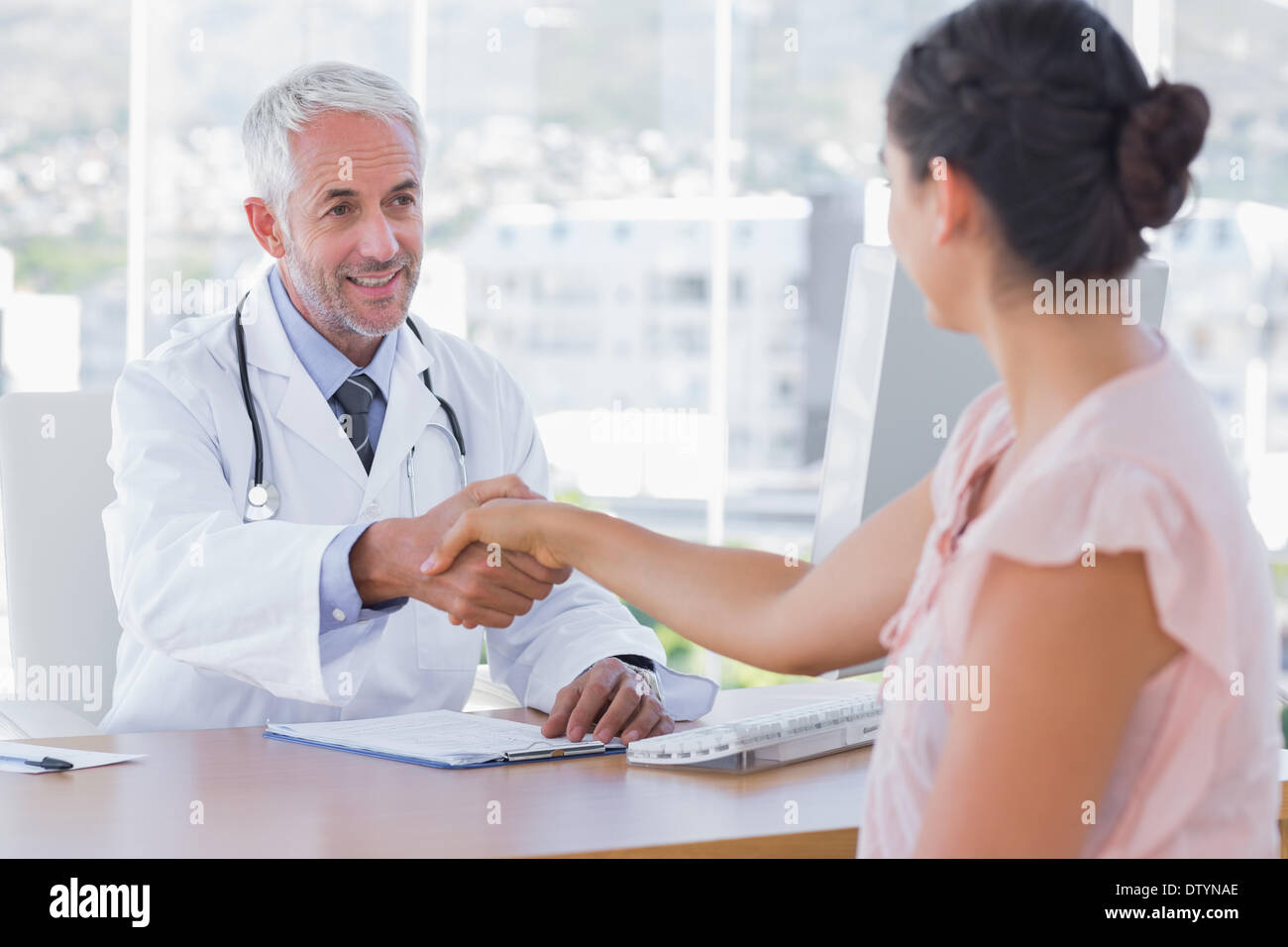 Doctor shaking hands to patient Stock Photo - Alamy