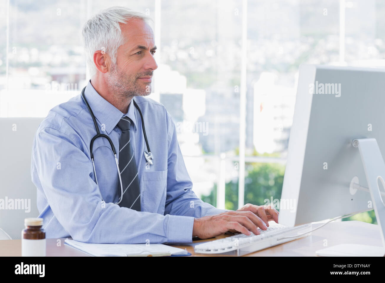 Doctor typing on his computer Stock Photo - Alamy
