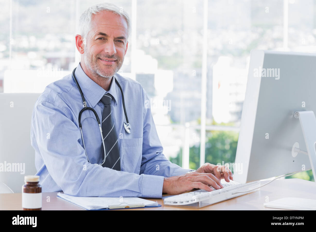 Doctor typing and using his computer Stock Photo - Alamy