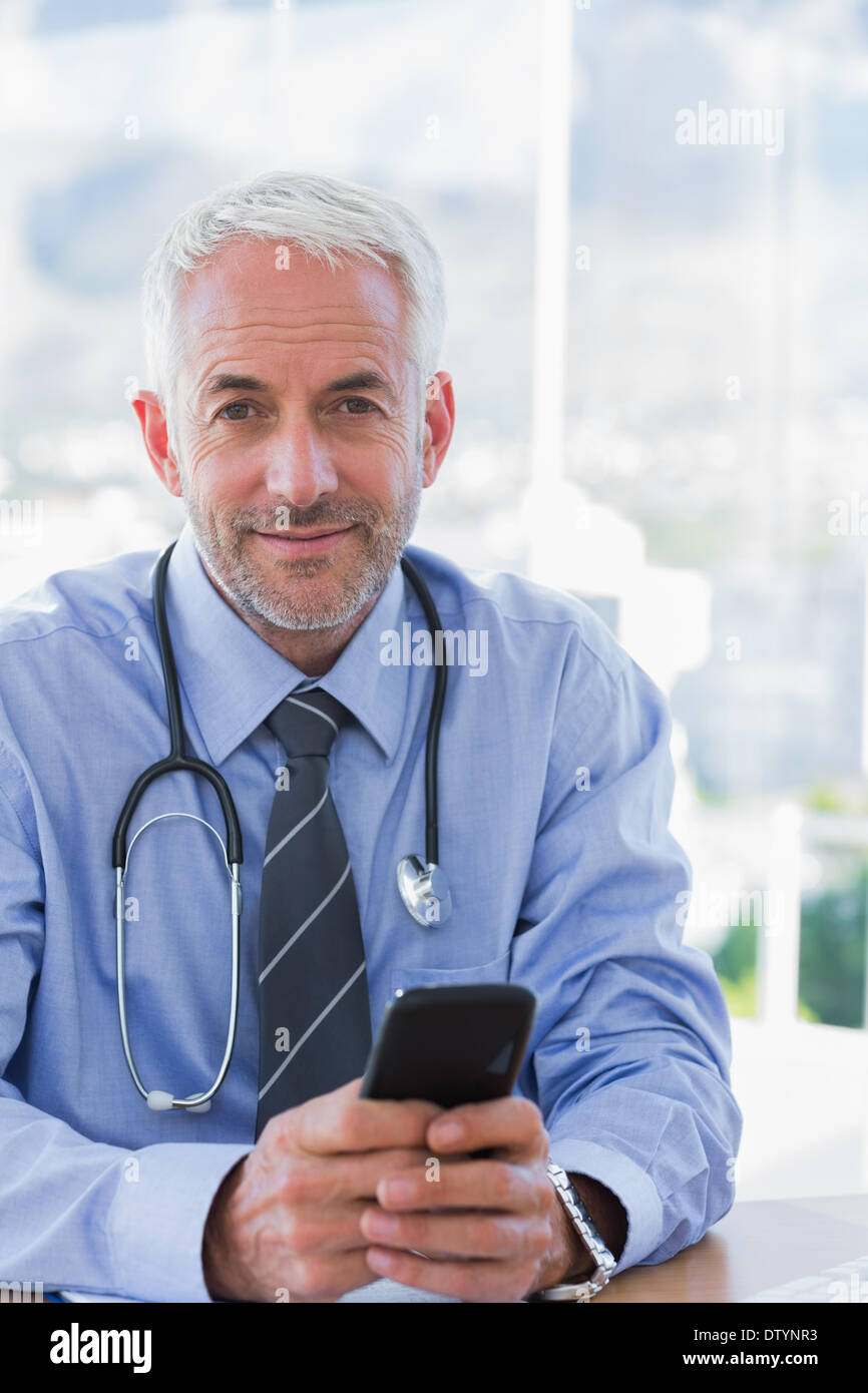 Smiling doctor texting mobile phone hi-res stock photography and images ...