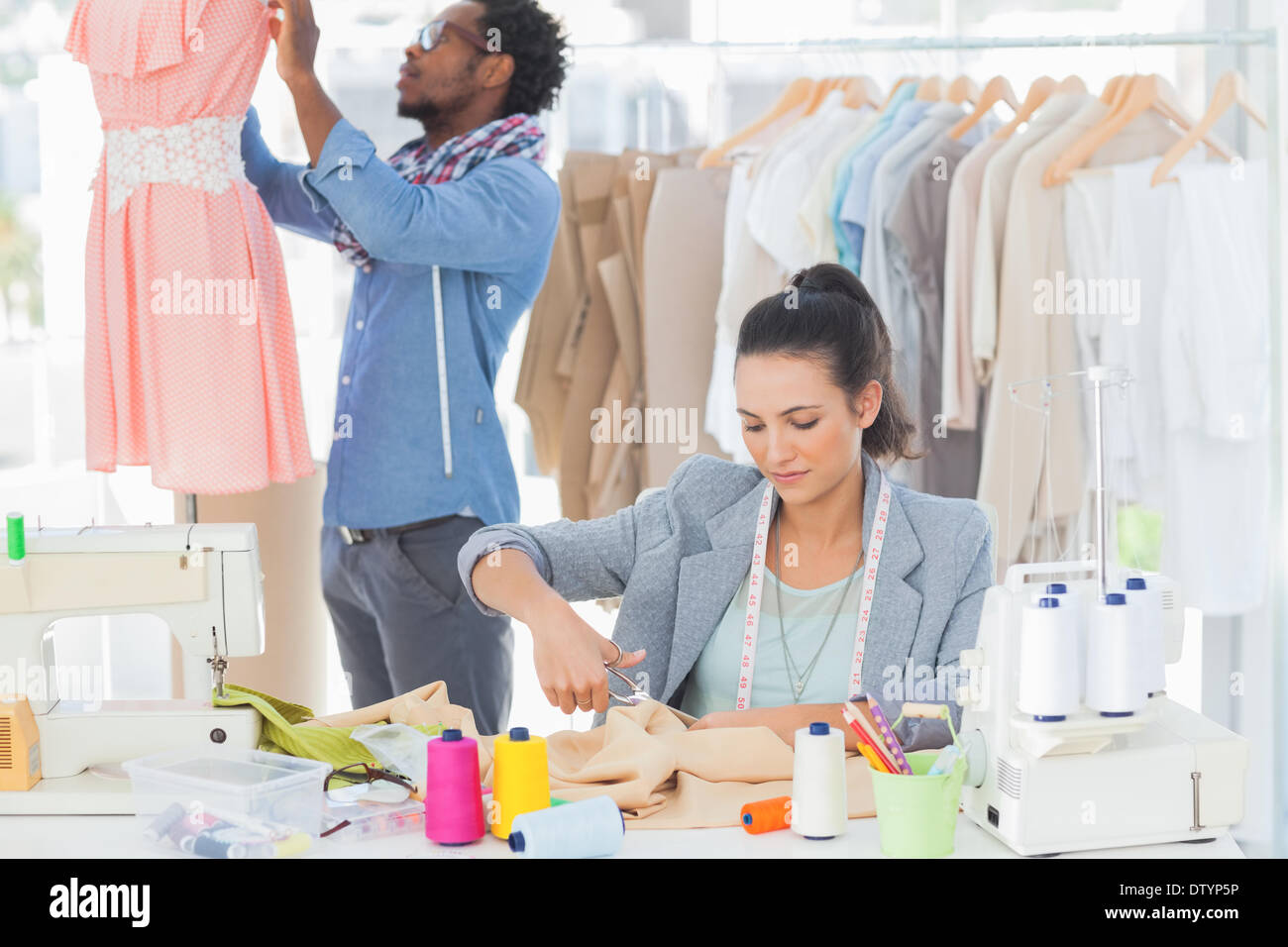 Fashion designer cutting textile at desk Stock Photo - Alamy