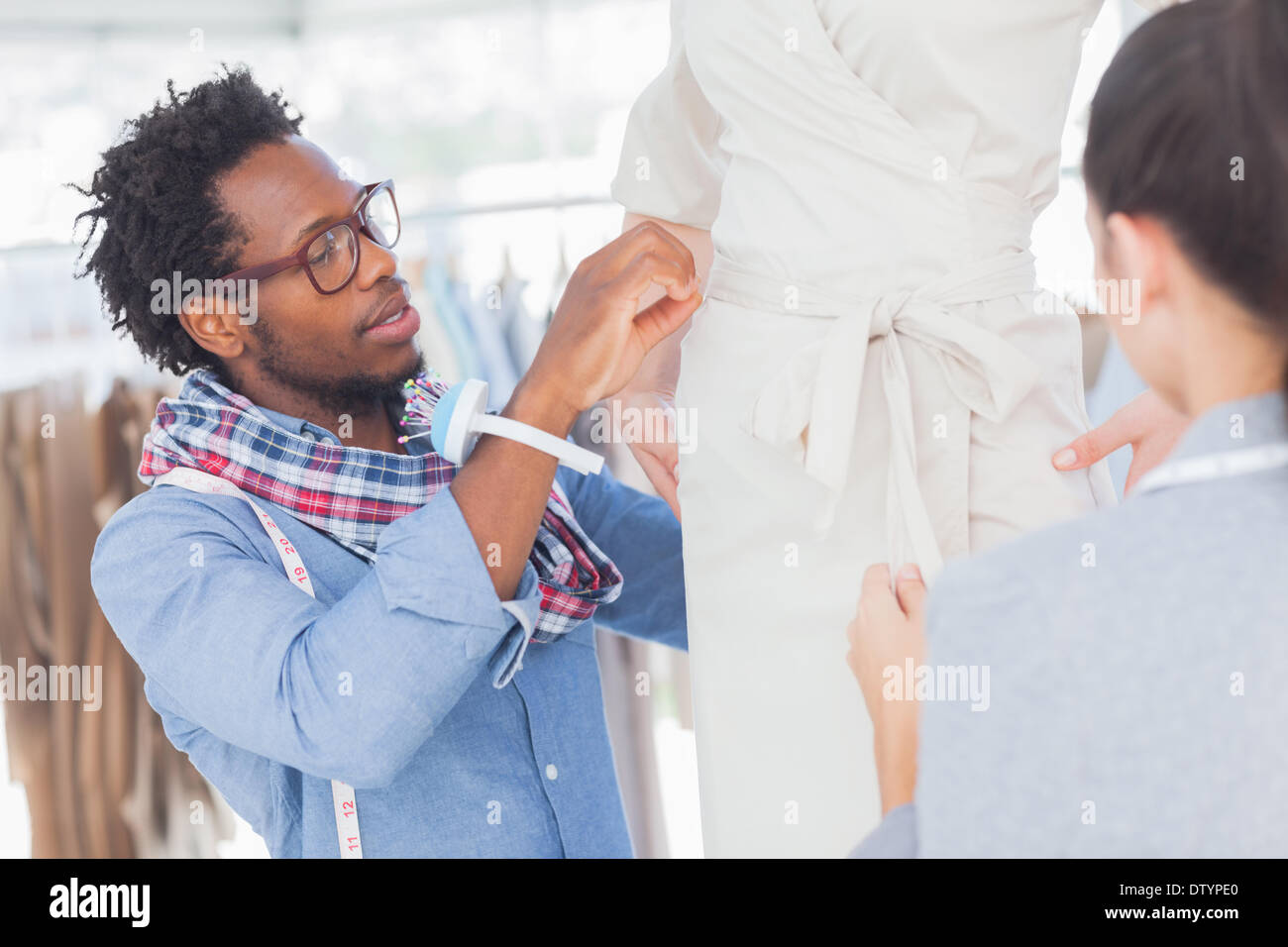 Fashion designers standing next to a model Stock Photo - Alamy