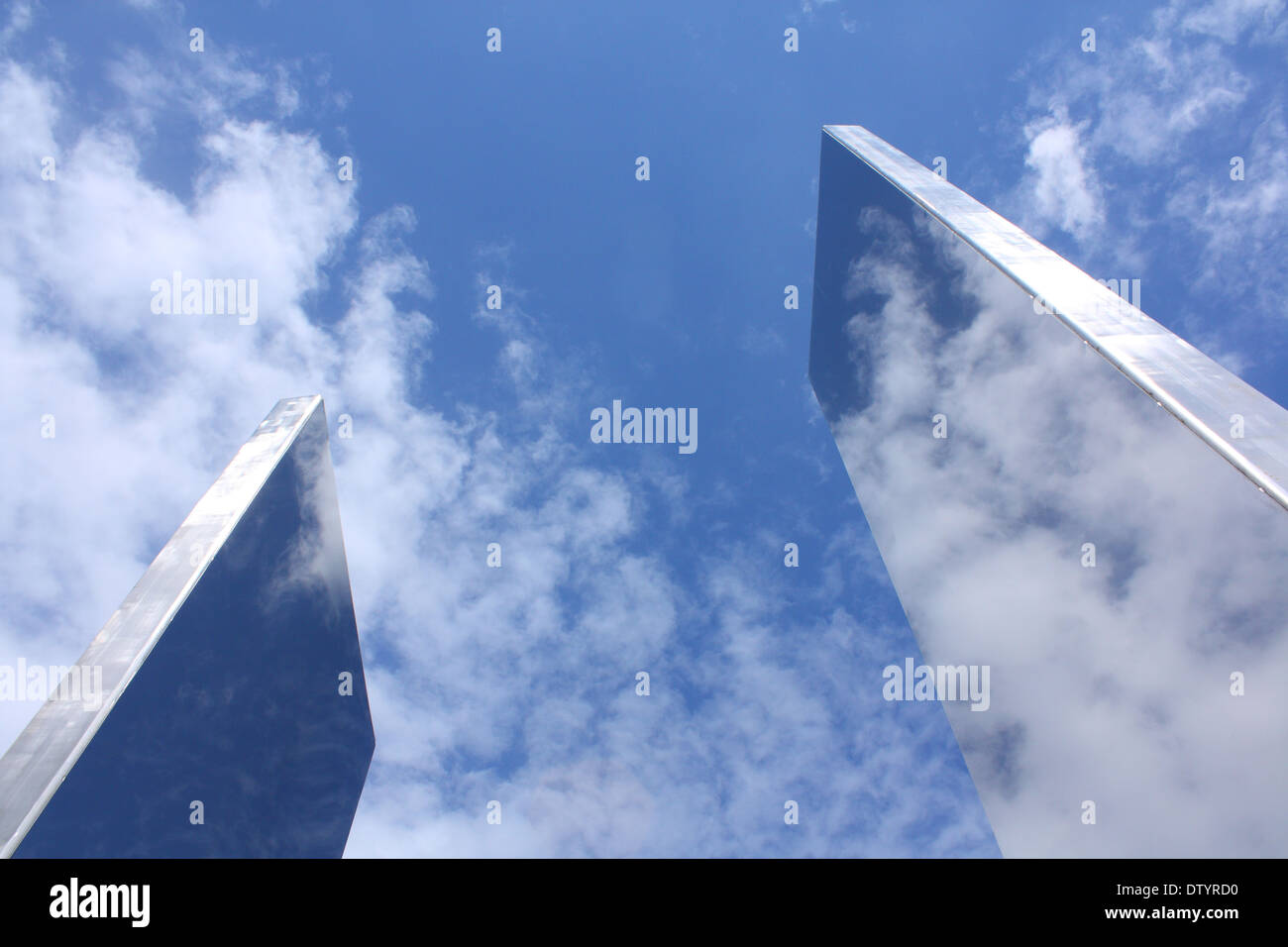 Two metal objects reflecting a blue sky with white clouds Stock Photo ...