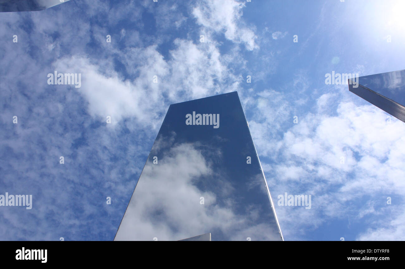 A metal object reflecting a blue sky with white clouds Stock Photo - Alamy