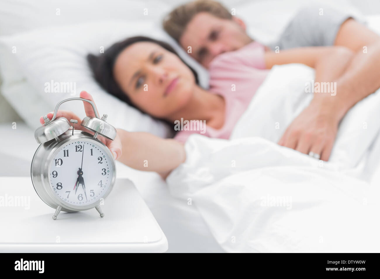 Woman turning off the alarm clock Stock Photo - Alamy
