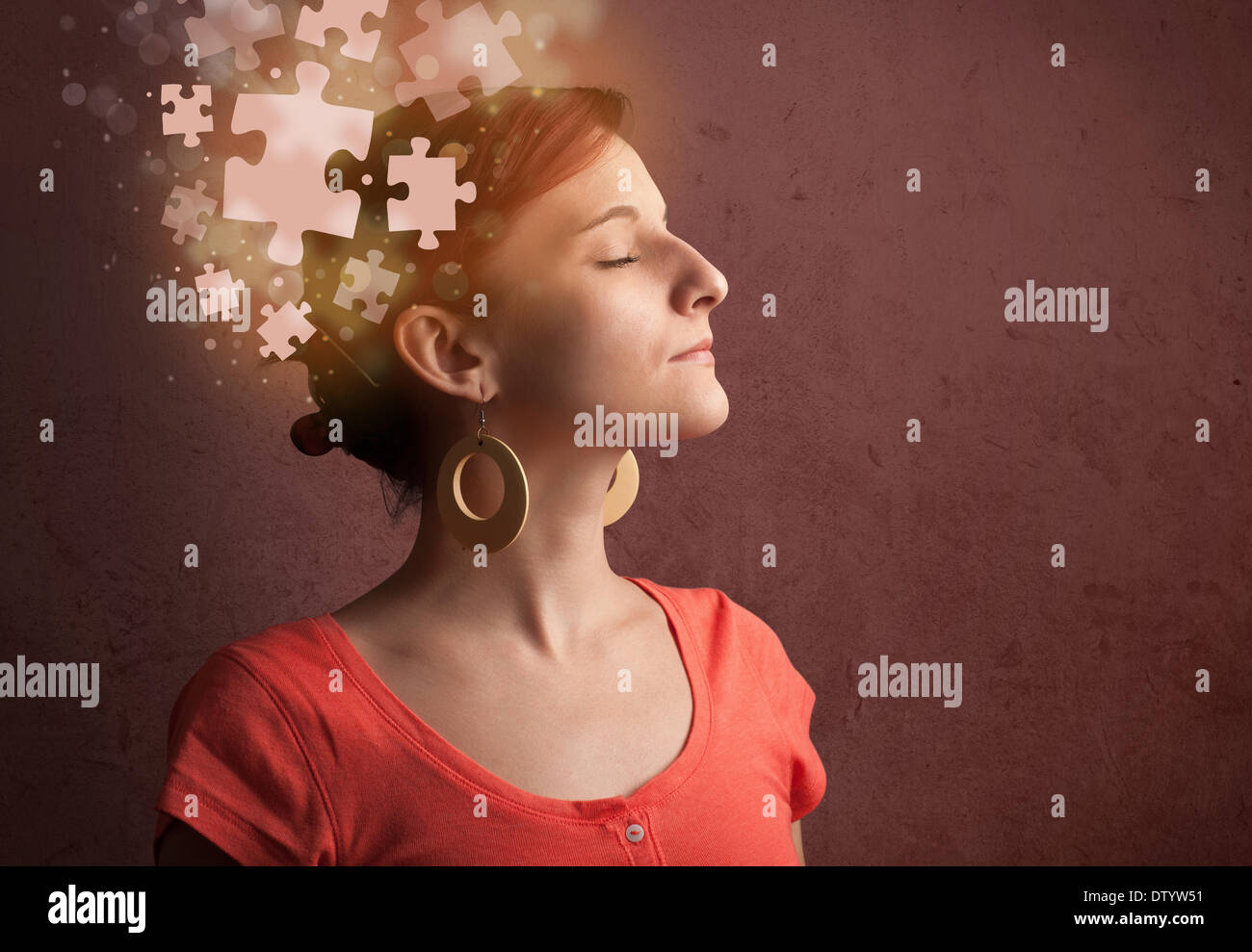 Young person thinking with glowing puzzle mind Stock Photo - Alamy