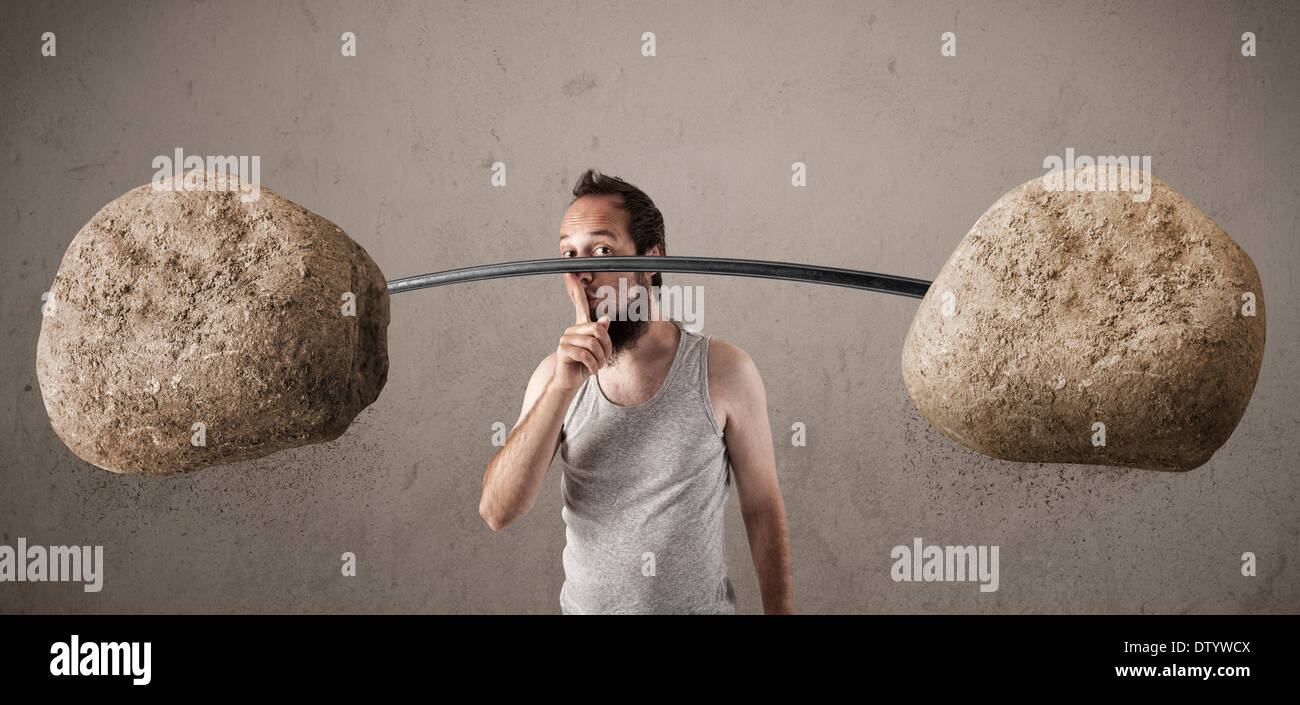 skinny guy lifting large rock stone weights Stock Photo - Alamy