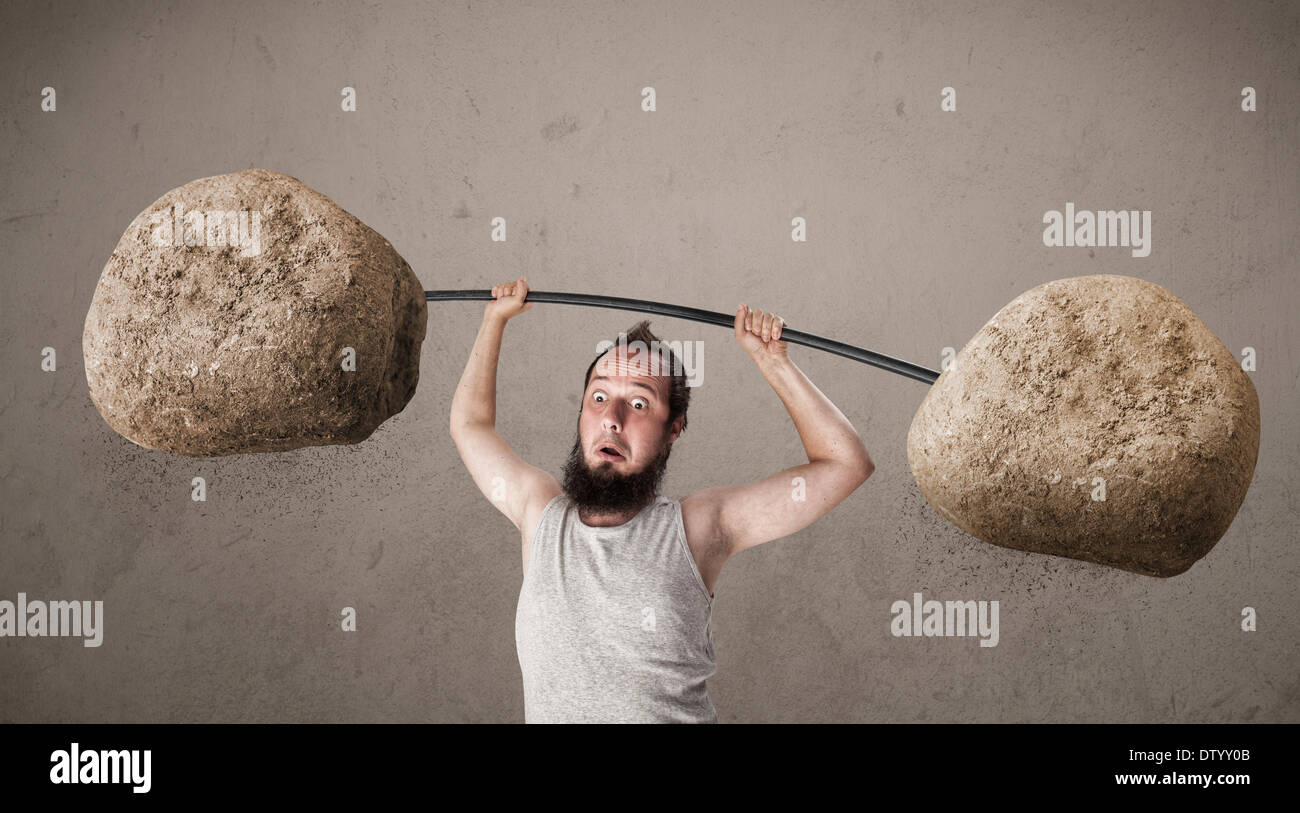 skinny guy lifting large rock stone weights Stock Photo - Alamy