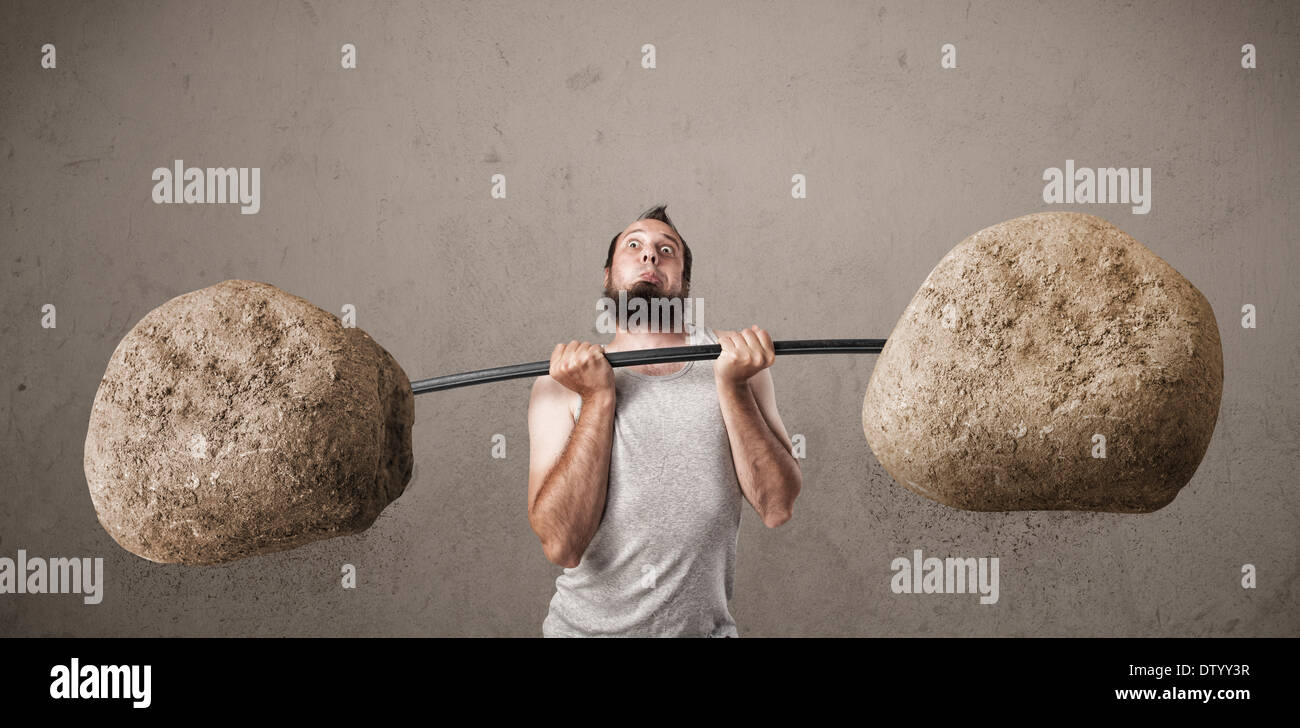 skinny guy lifting large rock stone weights Stock Photo - Alamy