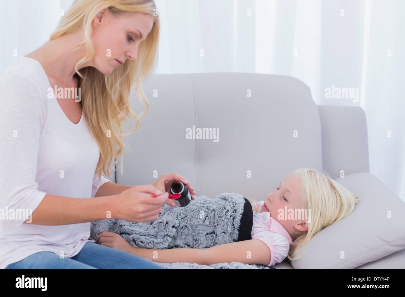 Mom giving her daughter medicine Stock Photo - Alamy