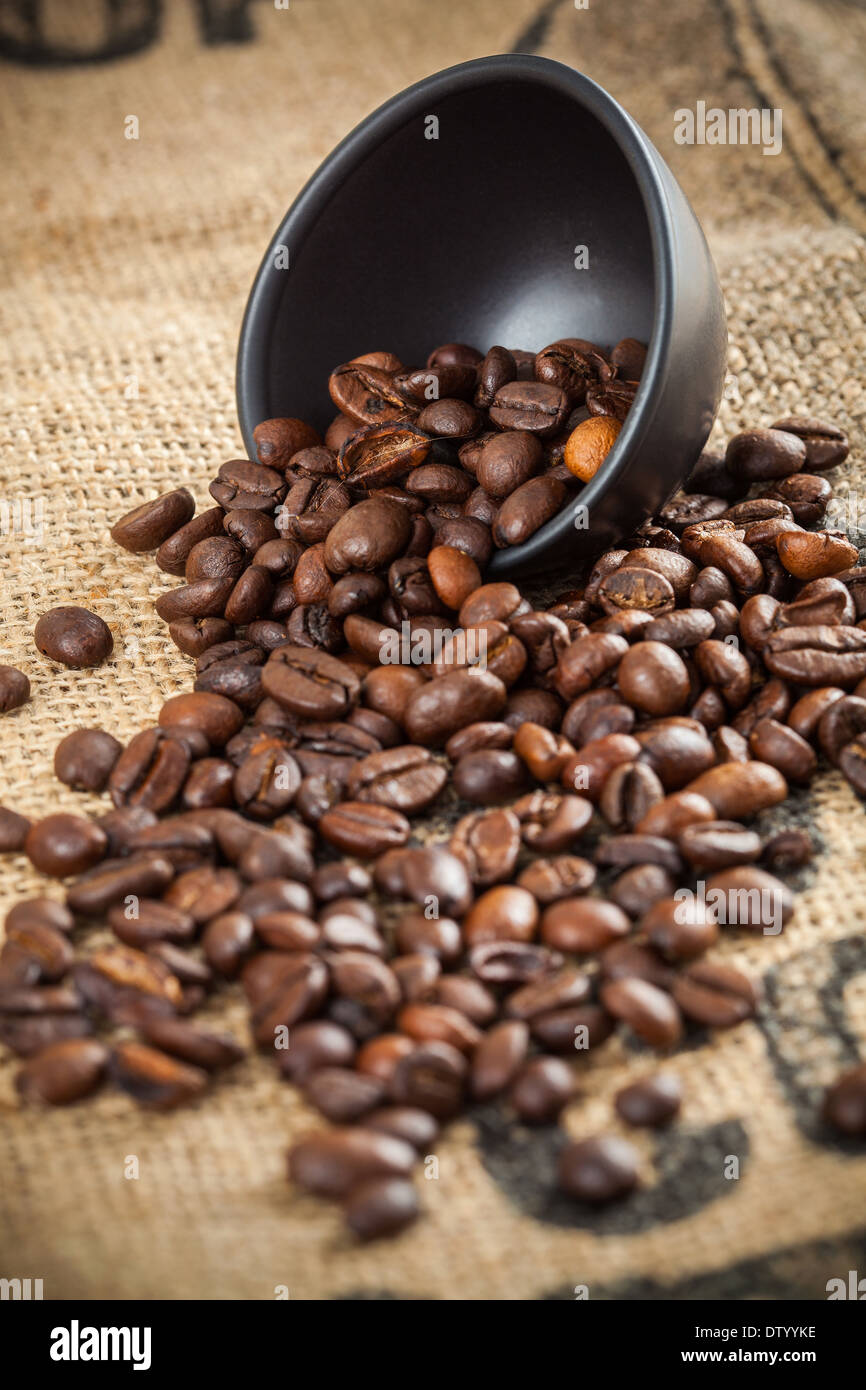 Spilled coffee beans and black cup Stock Photo - Alamy