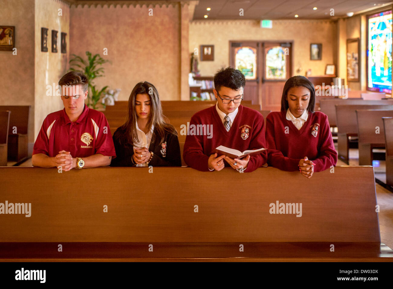 Caucasian, Asian American, and African American uniformed students pray ...