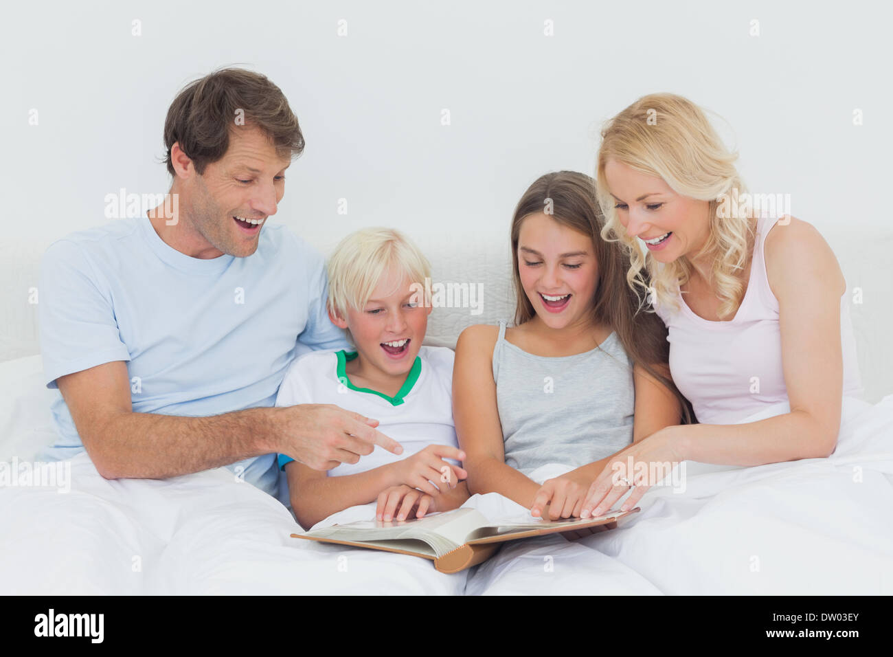 Family reading a book together Stock Photo - Alamy