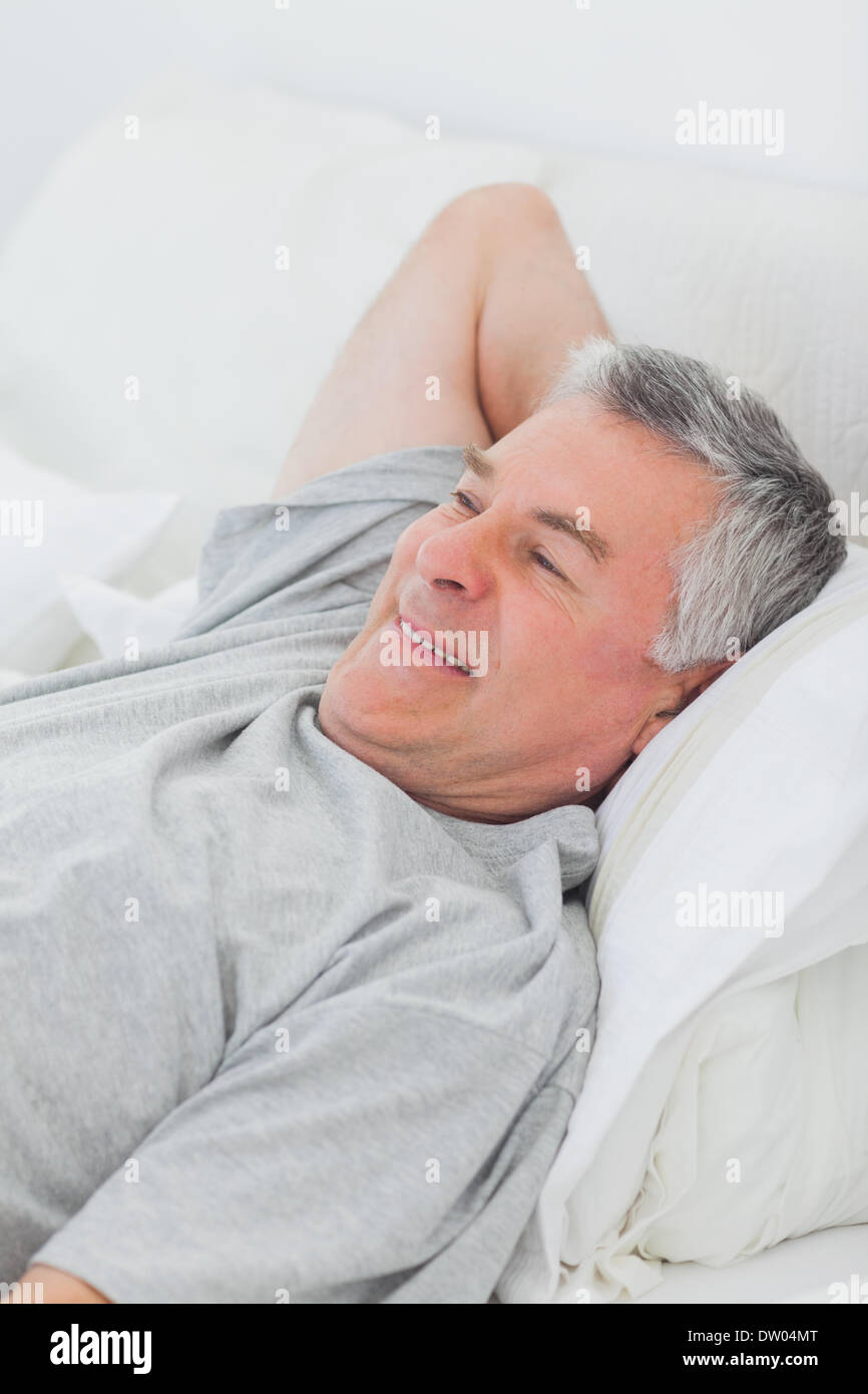 Cheerful man relaxing in bed Stock Photo - Alamy