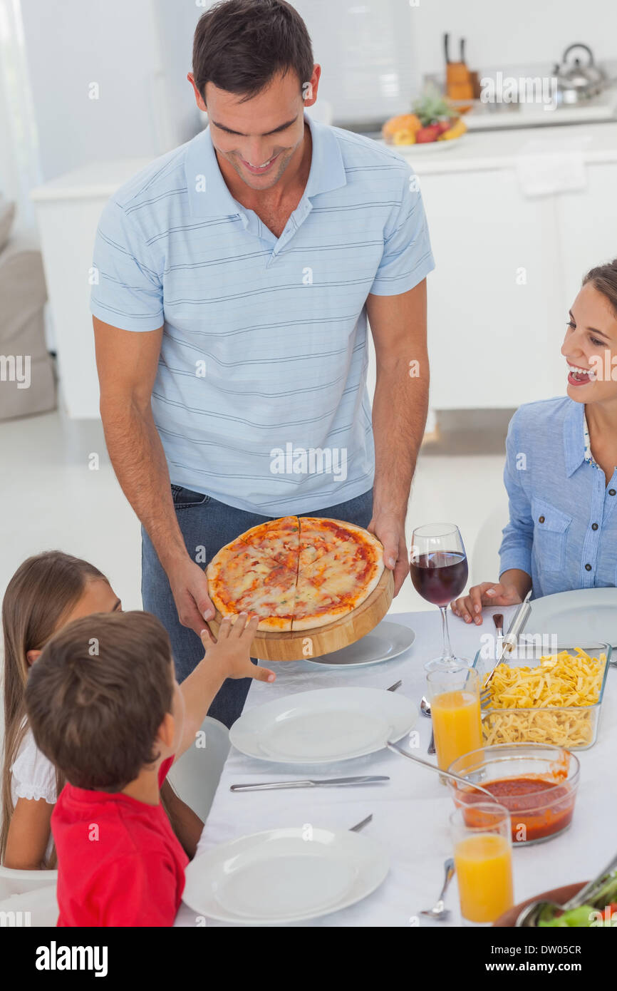 Handsome man bringing a pizza to his family Stock Photo - Alamy